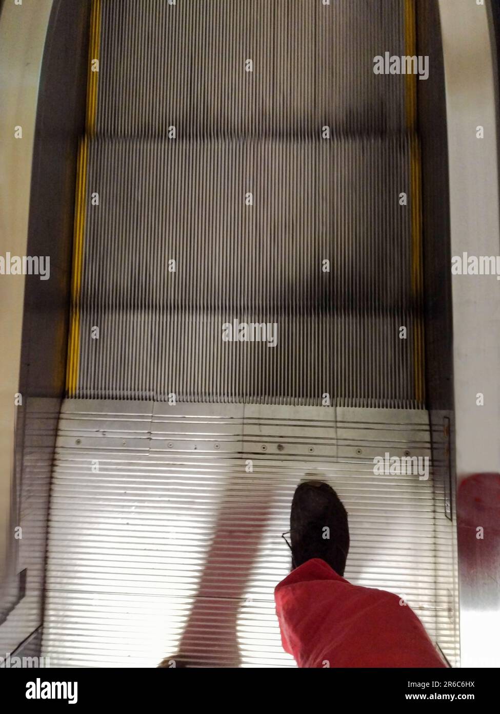 Vorsicht: Die Person, die auf die Rolltreppe tritt, bewegt sich sehr ...