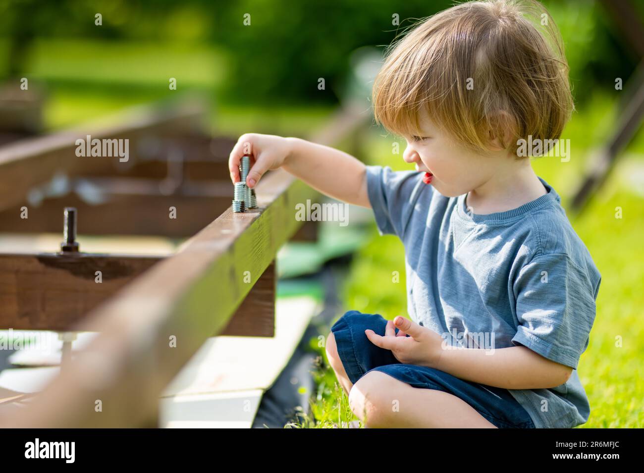 Süßer kleiner Junge, der seinem Großvater hilft. Senior-Mann, der an ...