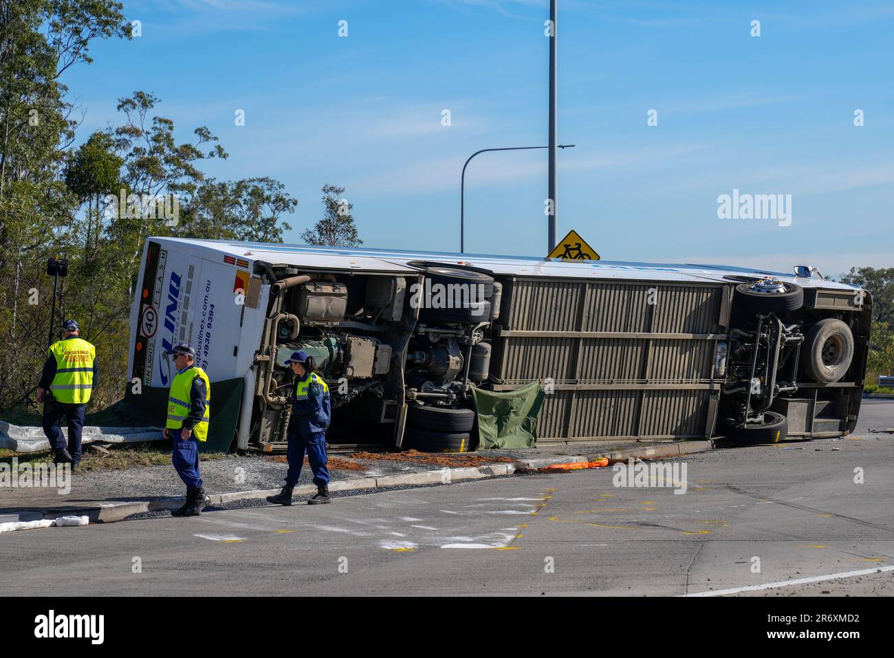 Police inspect underneath a bus that rolled onto its side near Greta in ...