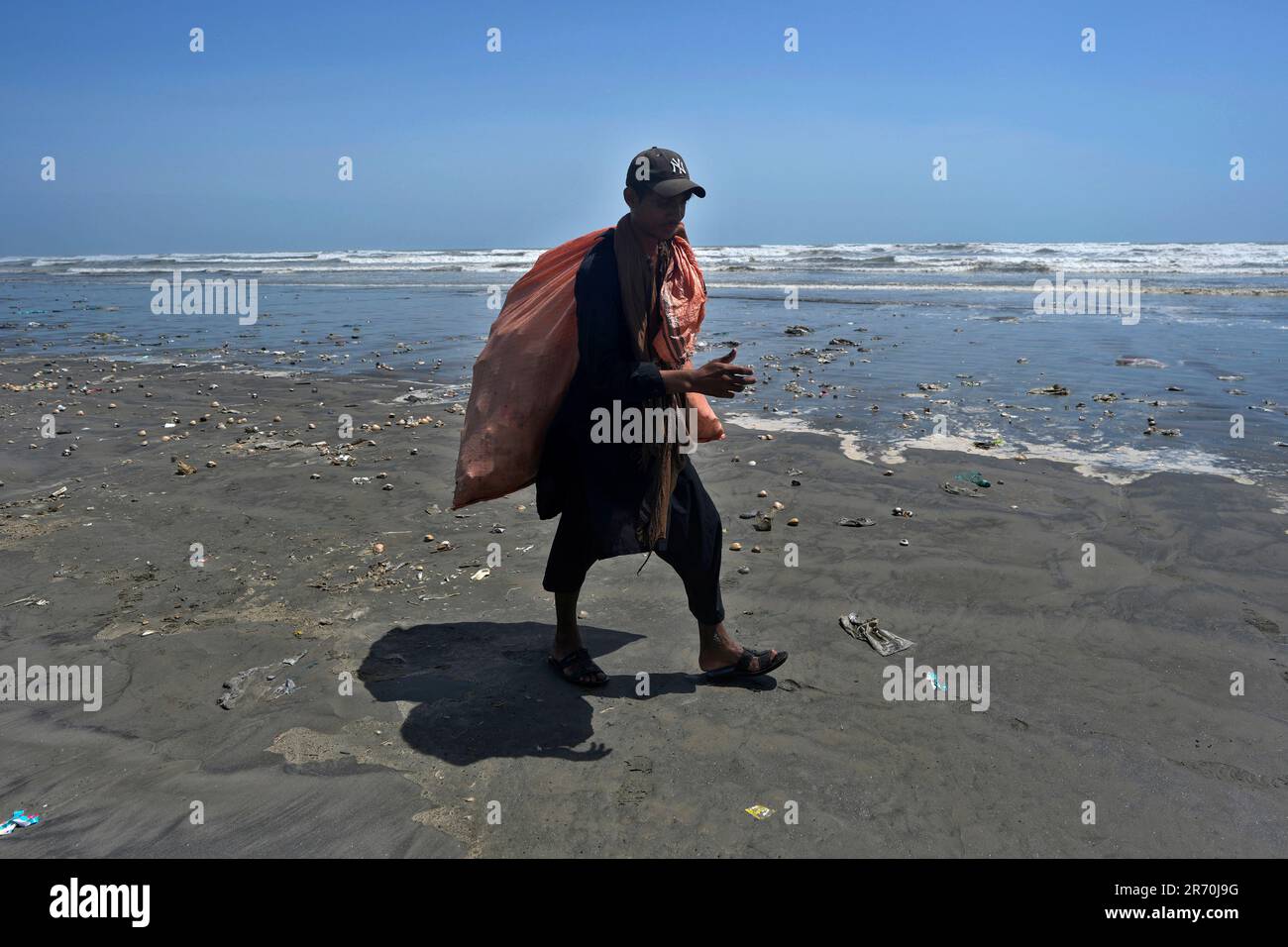 A scavenger searches usable and recyclable material at Clifton beach ...
