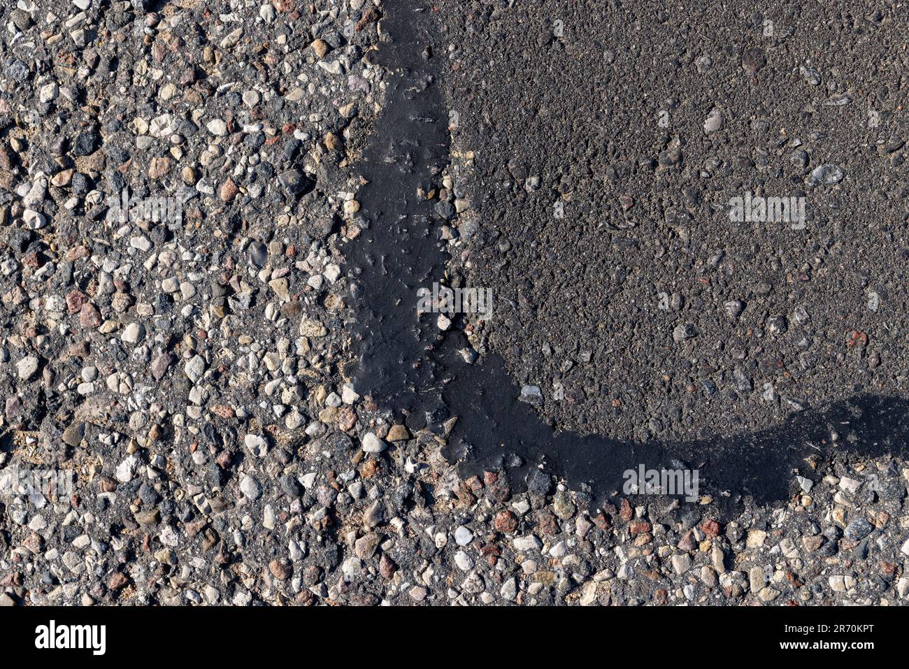 Der reparierte Teil einer Asphaltstraße mit Flecken, Reparatur und ...