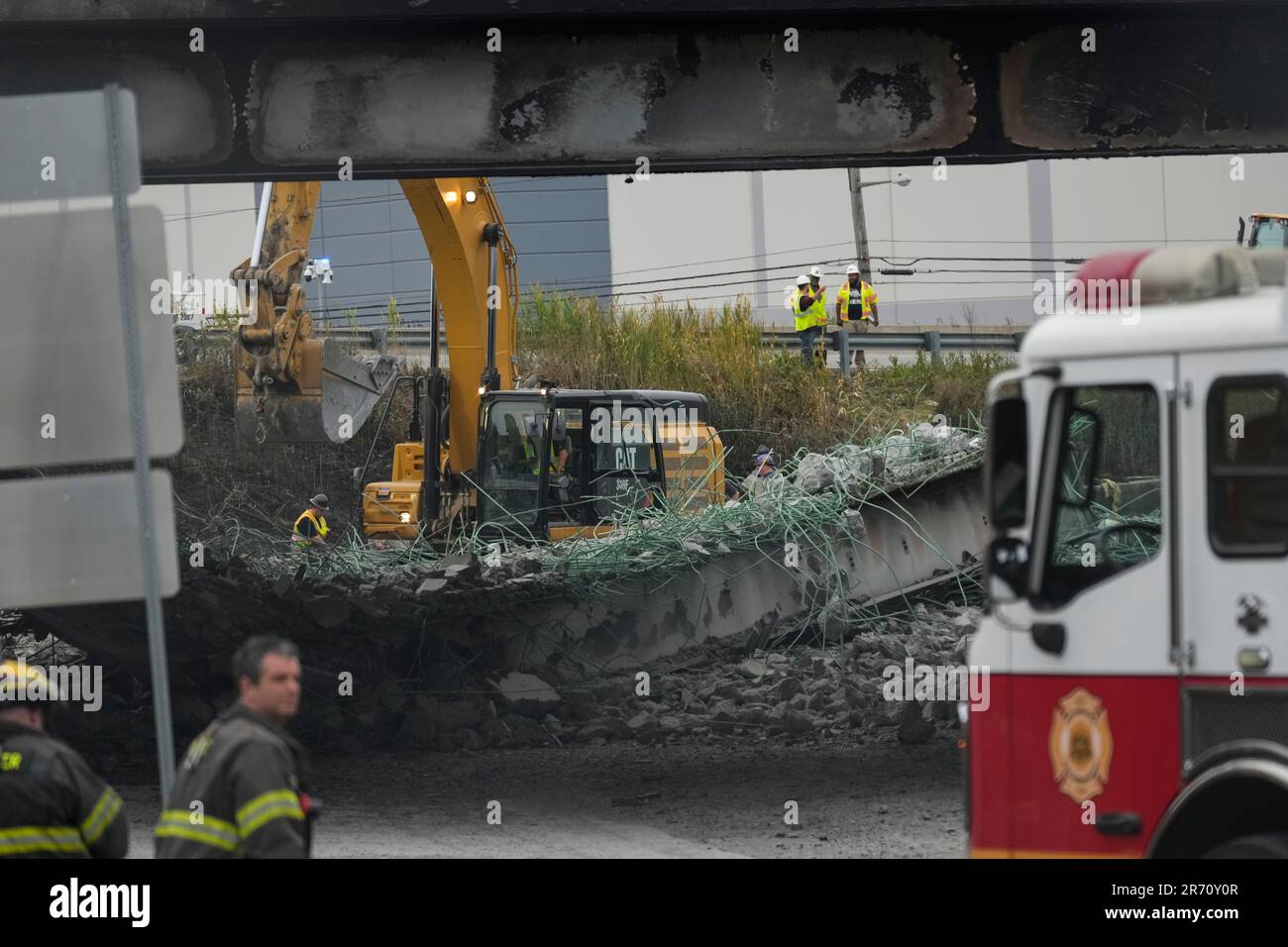 Firefighters and construction crews work near the aftermath of an ...