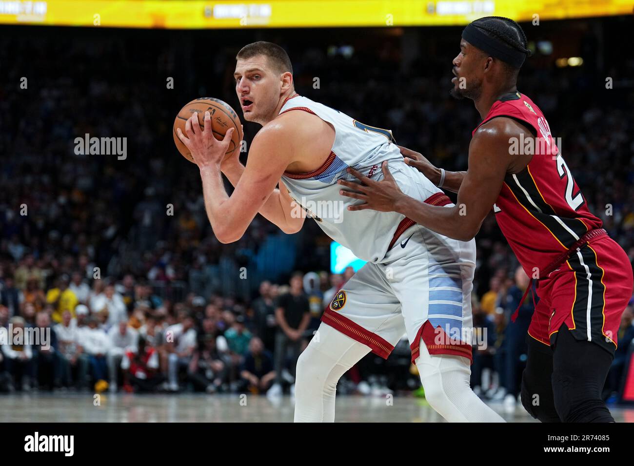 Denver Nuggets center Nikola Jokic, left, is defended by Miami Heat forward Jimmy Butler, right ...