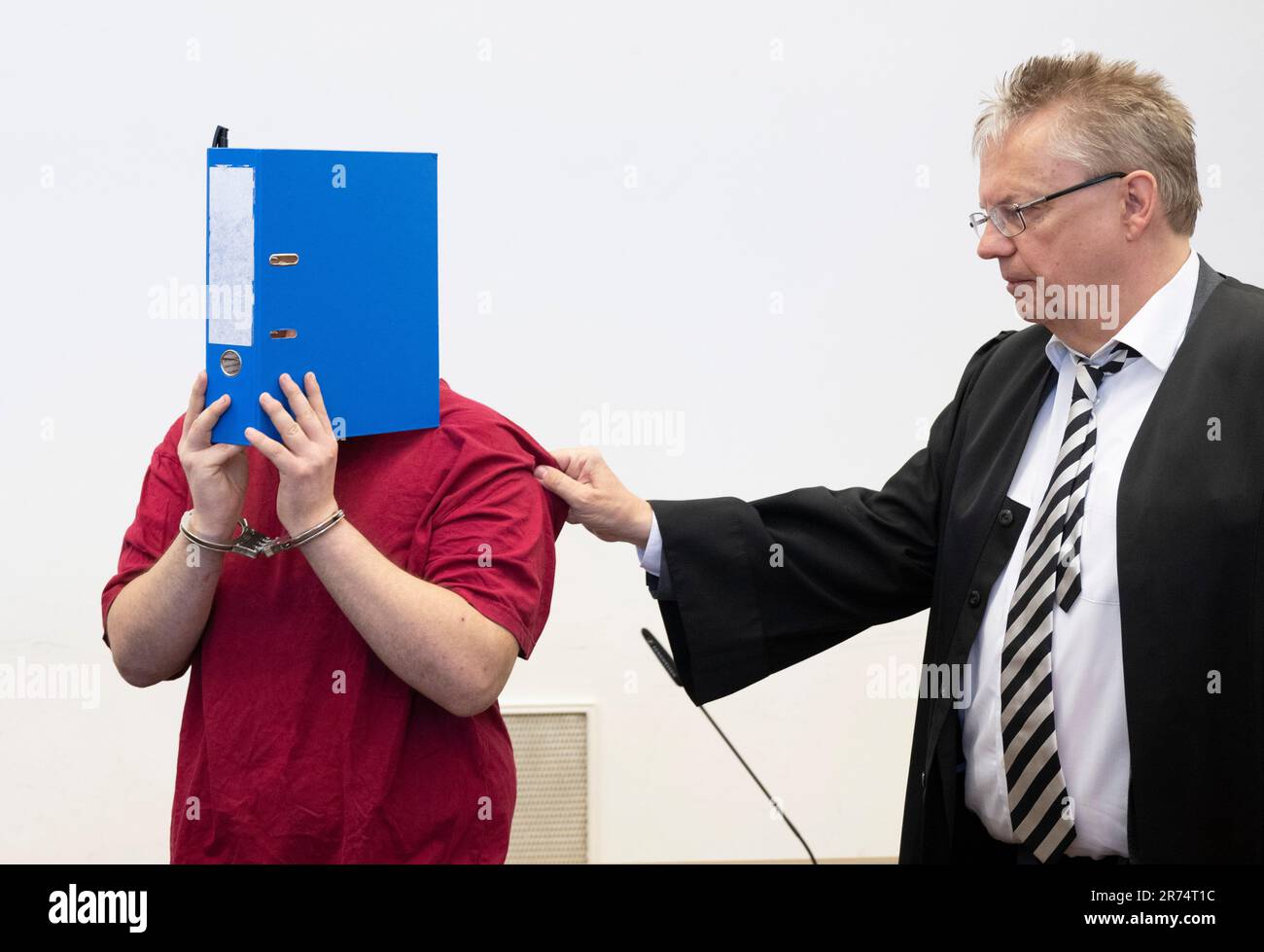 13. Juni 2023, Hesse, Gießen: Der Beklagte (l) steht im Gerichtssaal ...