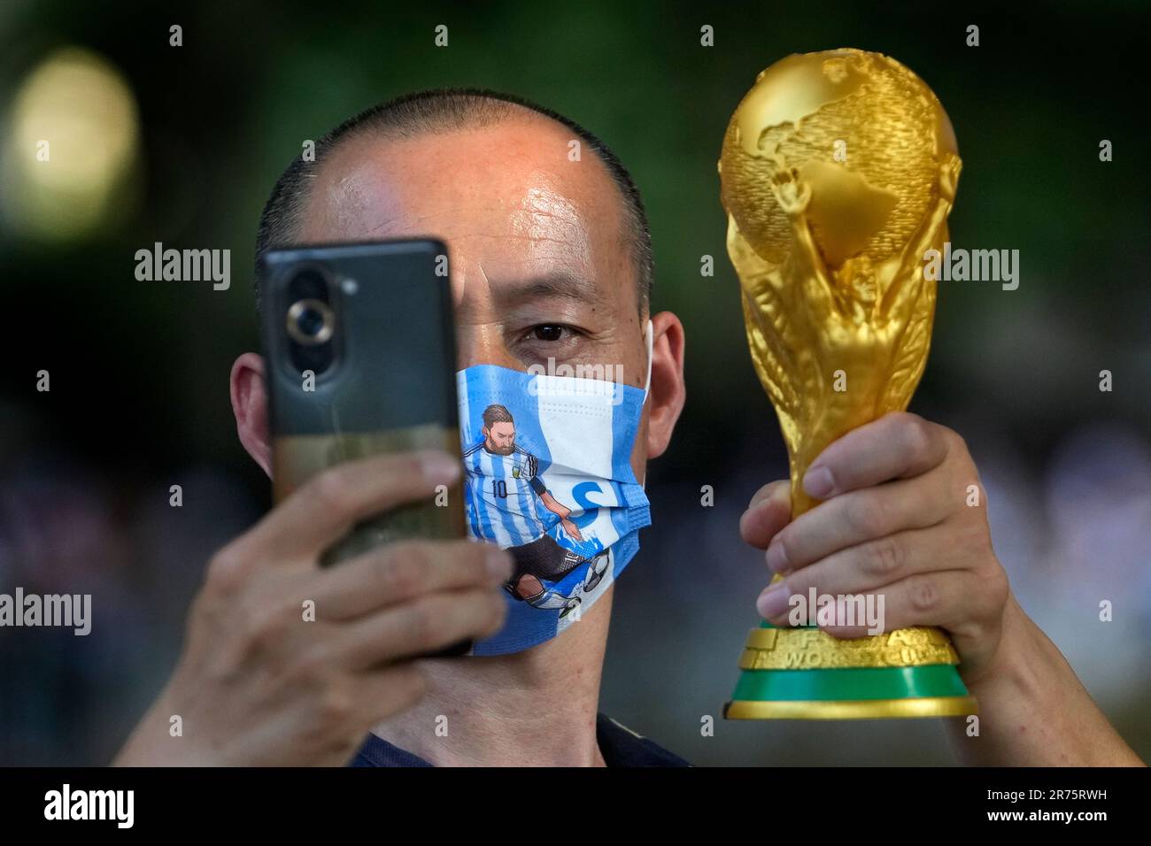 A man wearing a face mask with a picture of superstar Lionel Messi ...