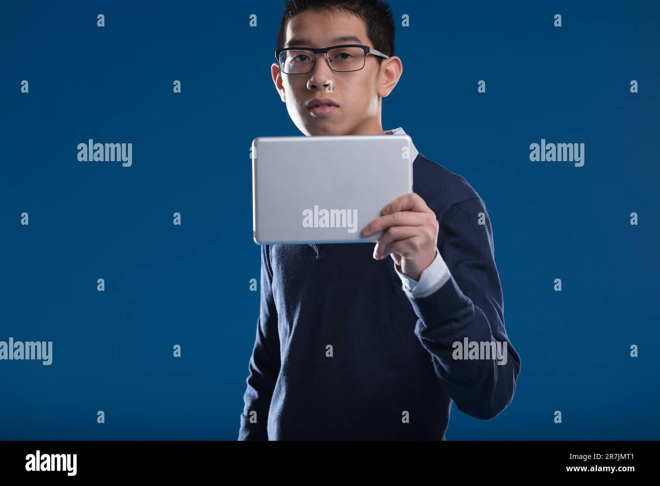 Ein Asiate überprüft Nachrichten auf seinem Tablet, hält an, um hier zu ...