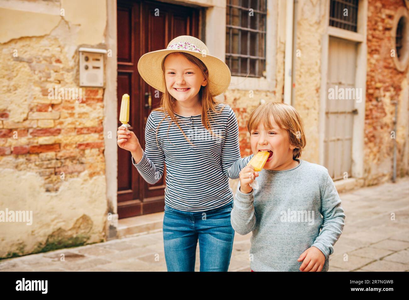 Zwei lustige Kinder, die durch die alten italienischen Straßen spazieren, Familie tavel mit ...