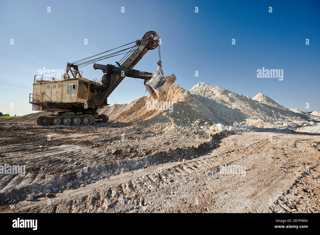 Der Bagger wird in großen offenen Steinbrüchen vor blauem Himmel ...