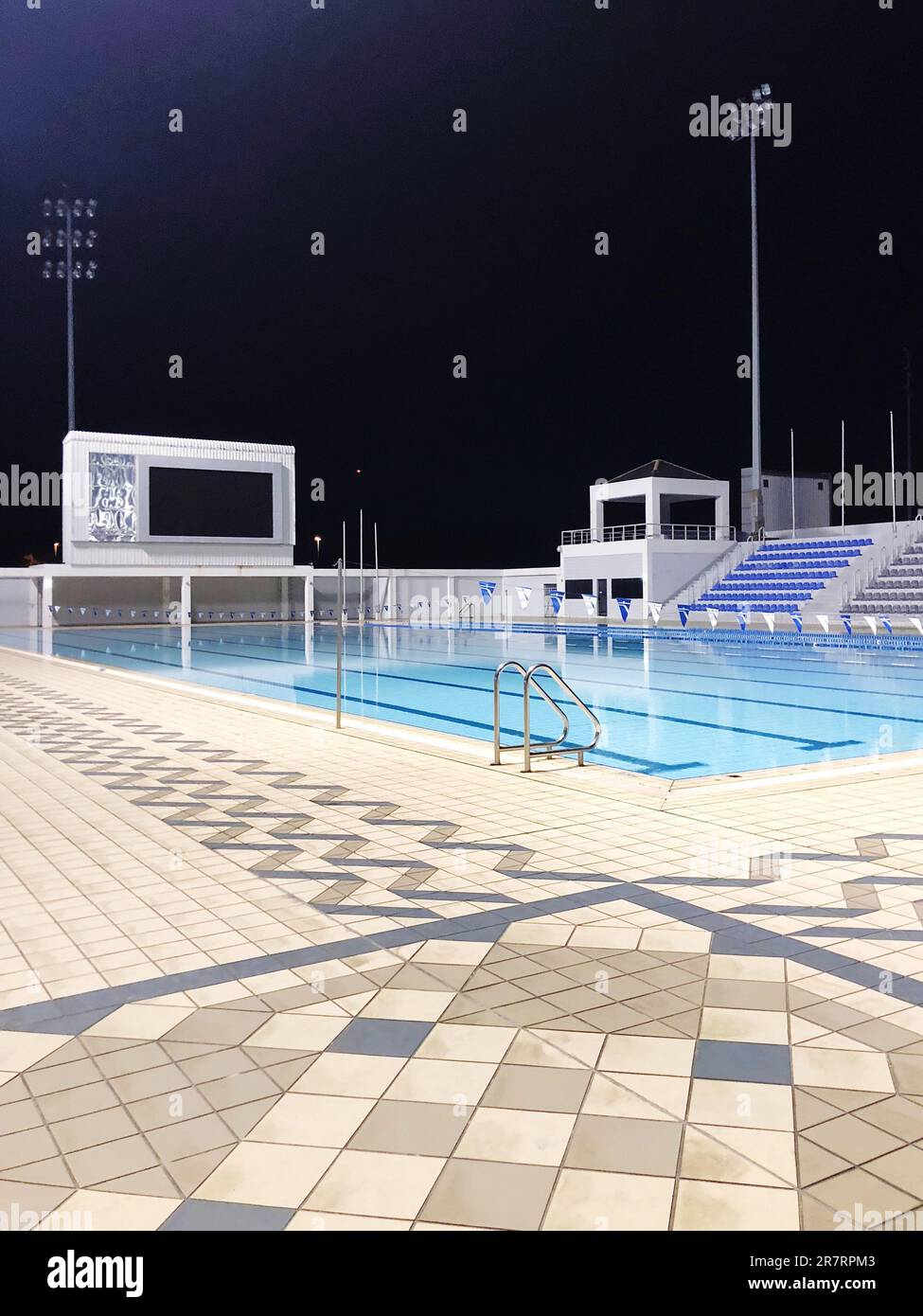 Ein abendlicher Blick auf einen verlassenen Swimmingpool, der von den ...