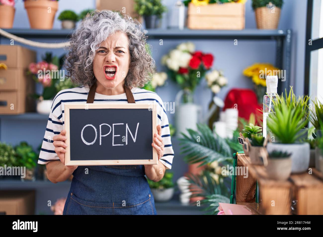 Eine Frau mittleren Alters mit grauen Haaren, die beim Floristen ...