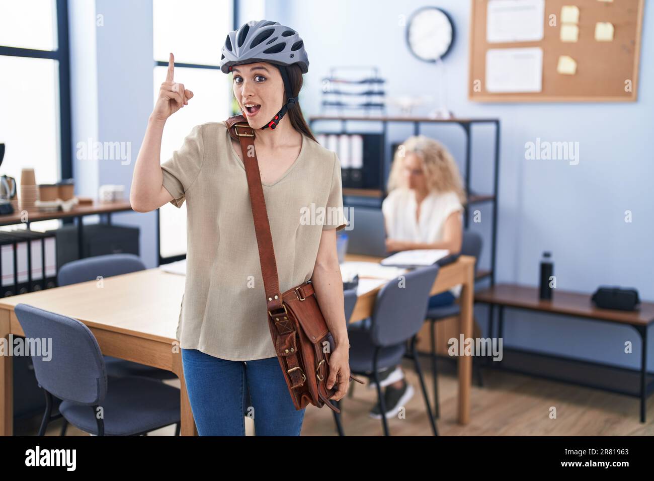 Junge Brünette Frau Die Im Büro Arbeitet Und Einen Fahrradhelm Trägt überrascht Von Einer Idee