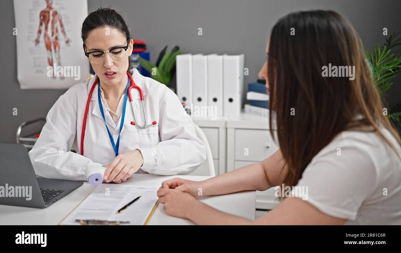 Zwei Ärztinnen und eine Patientin, die einen Laptop benutzen und sich ... Zwei Ärztinnen und eine Patientin, die einen Laptop benutzen und sich ...