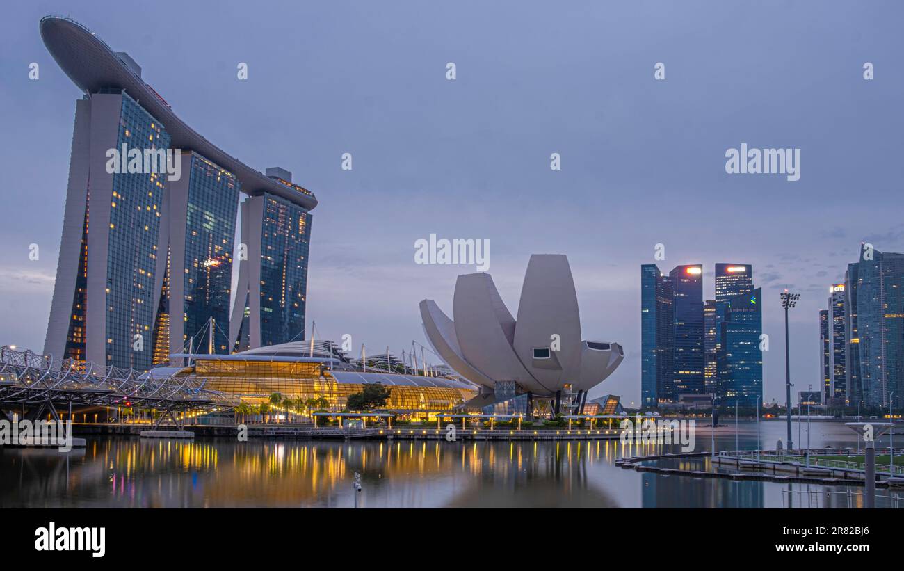Das Marina Bay Sands Hotel in Singapur ist in der Dämmerung beleuchtet, mit der geschäftigen ...