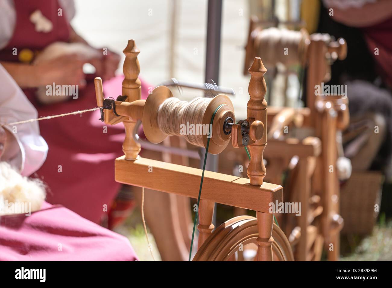 Spinnrad aus Holz mit rotierendem Spulenkörper in Bewegungsunschärfe ...