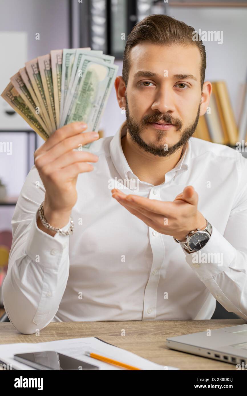 Ein junger Boss, der Geld zeigt, gibt Ihnen das Gehalt, zufrieden mit ...