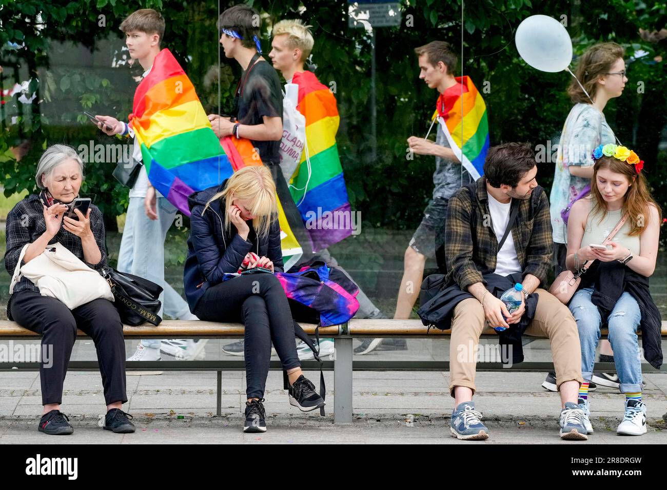 People sit on a bench as participants in Poland's yearly Pride parade ...