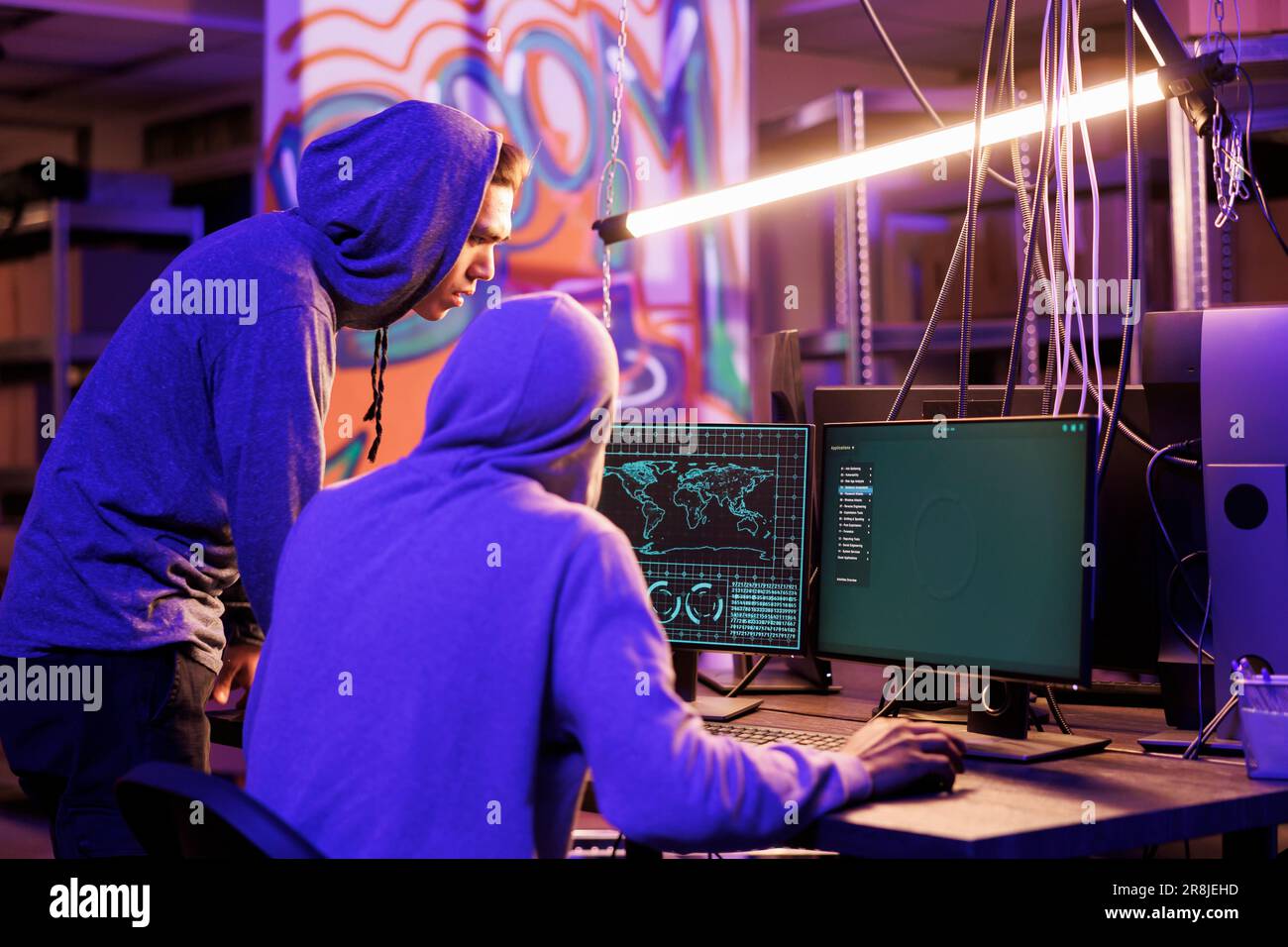 Zwei Hacker in Kapuzen brechen in das Netzwerksystem ein und greifen auf das Dark Web zu. Junge ...