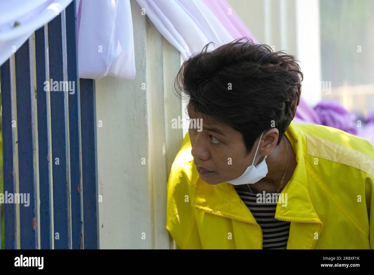 A Thai parent looks inside a school in Bangkok, Thailand, Friday, June ...