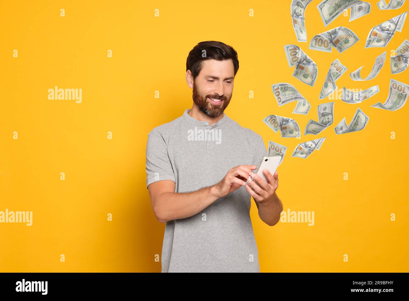 Online-Zahlung. Ein Mann kauft etwas mit einem Handy auf gelbem ...