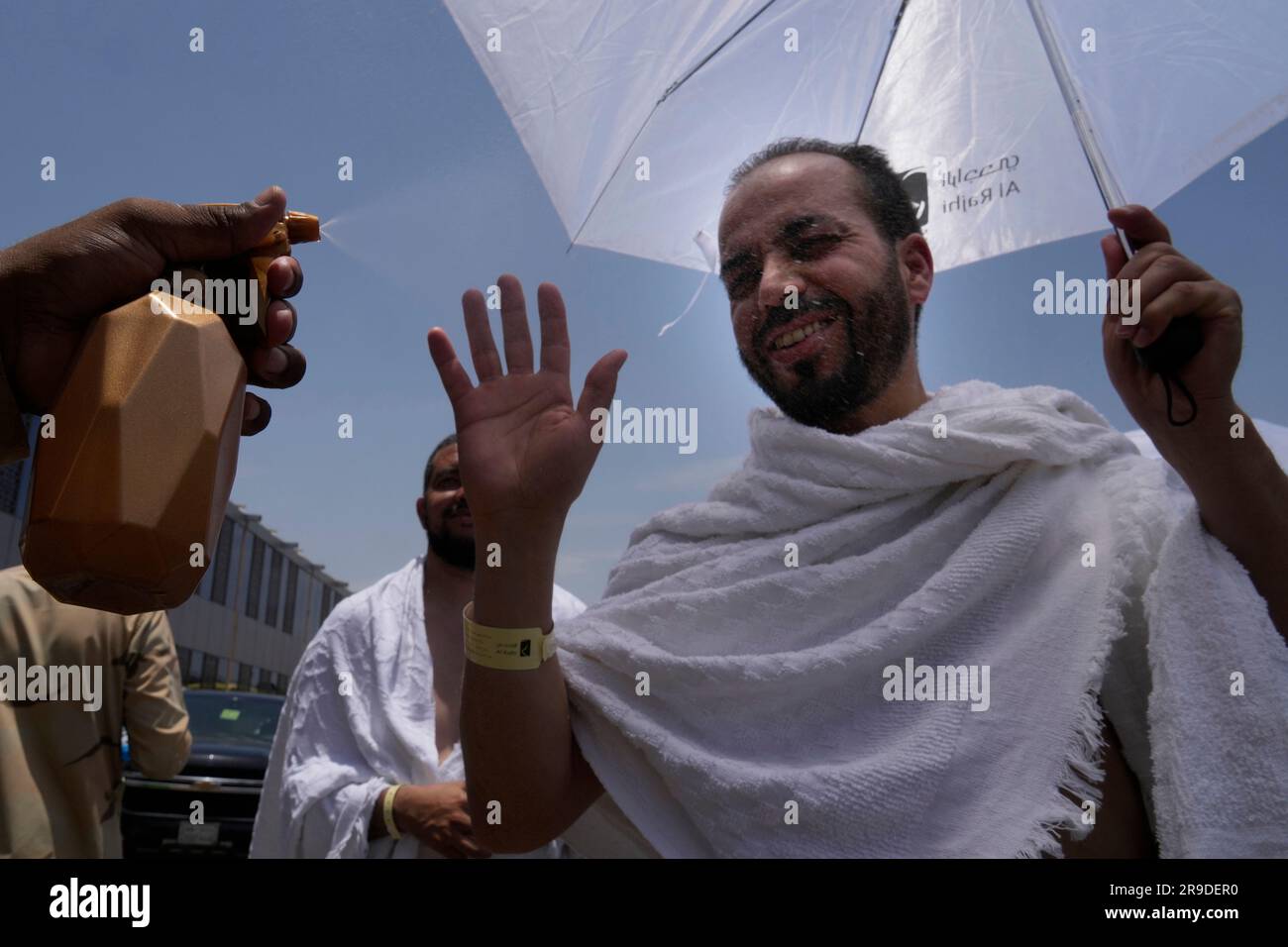 A police officer sprays cold water at a Muslim pilgrim at the Mina tent ...
