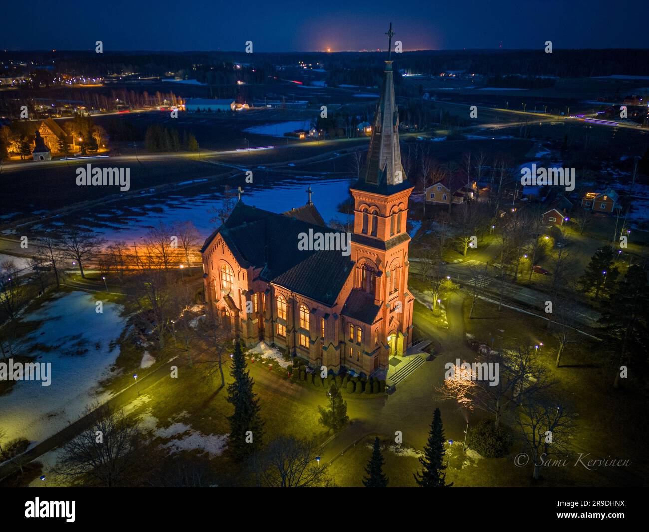 Eine beleuchtete Kirche steht in der Nacht, ihre Fassade hell ...