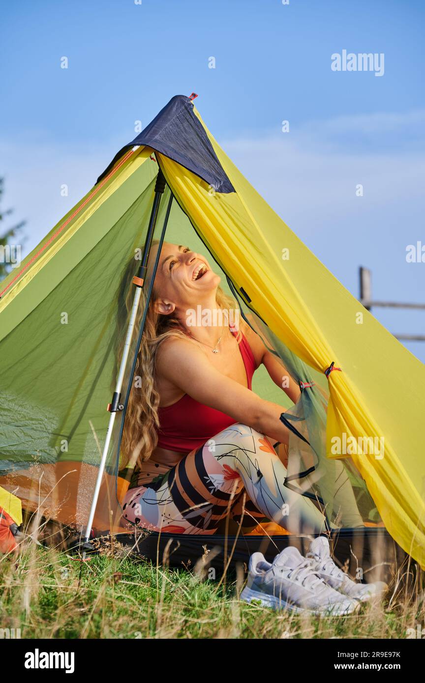 Frauen, die im Freien campen. Schlanke, blonde Frau, die im Zelt auf ...