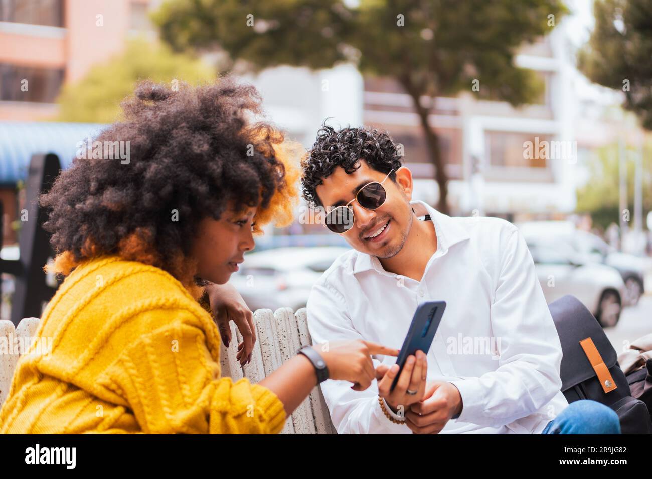 Glückliche schwarze Frau mit Afro-gelbem Haar in lässiger Kleidung, die ... Glückliche schwarze Frau mit Afro-gelbem Haar in lässiger Kleidung, die ...