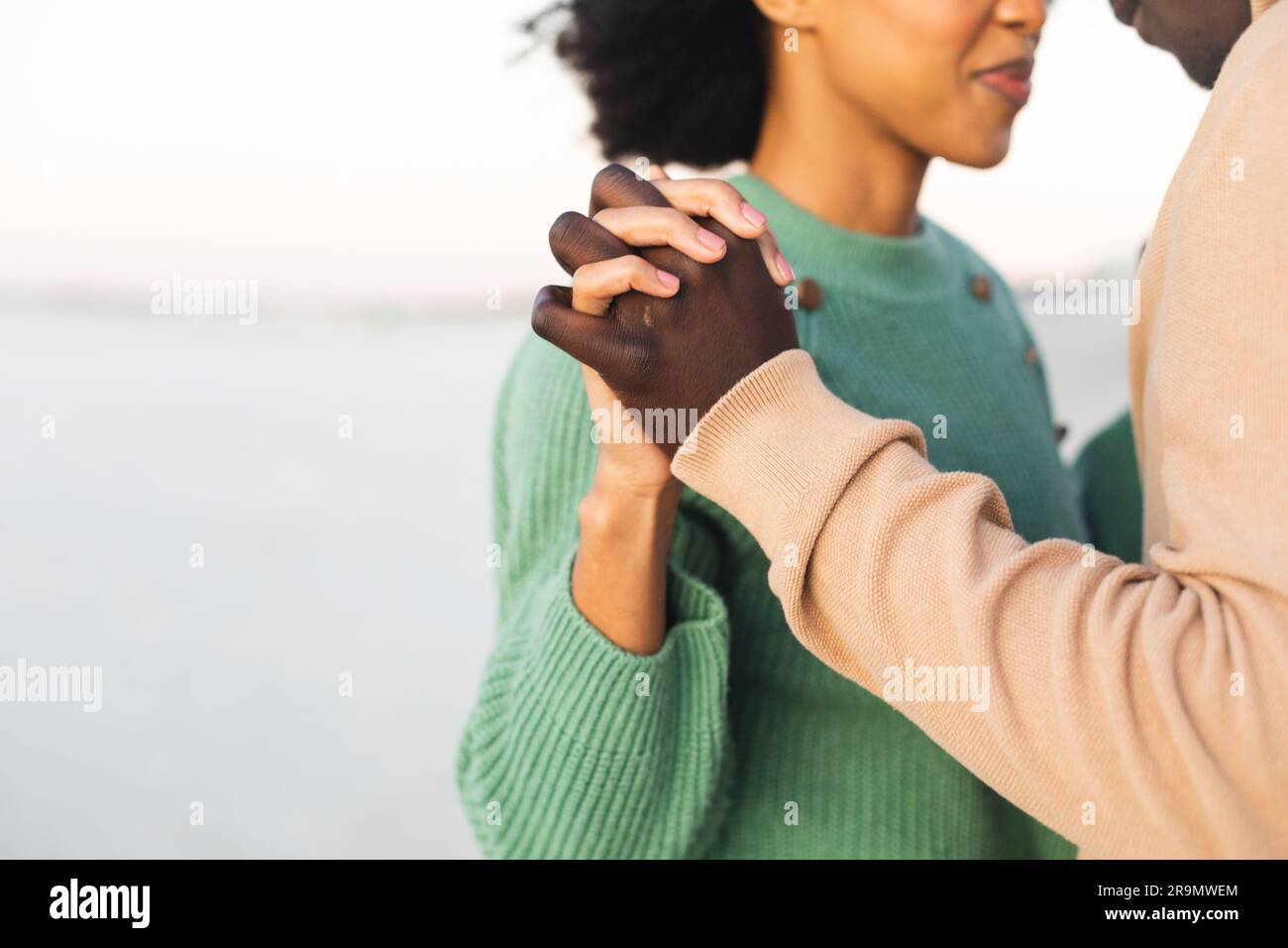 Mitten in einem glücklichen afroamerikanischen Paar, das Händchen hält ...