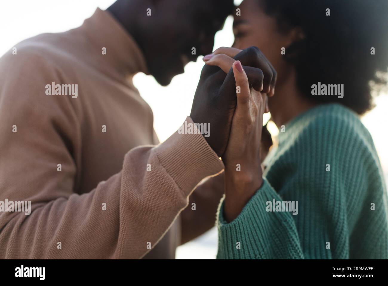 Glückliches afroamerikanisches Paar, das Händchen hielt und am Strand ...