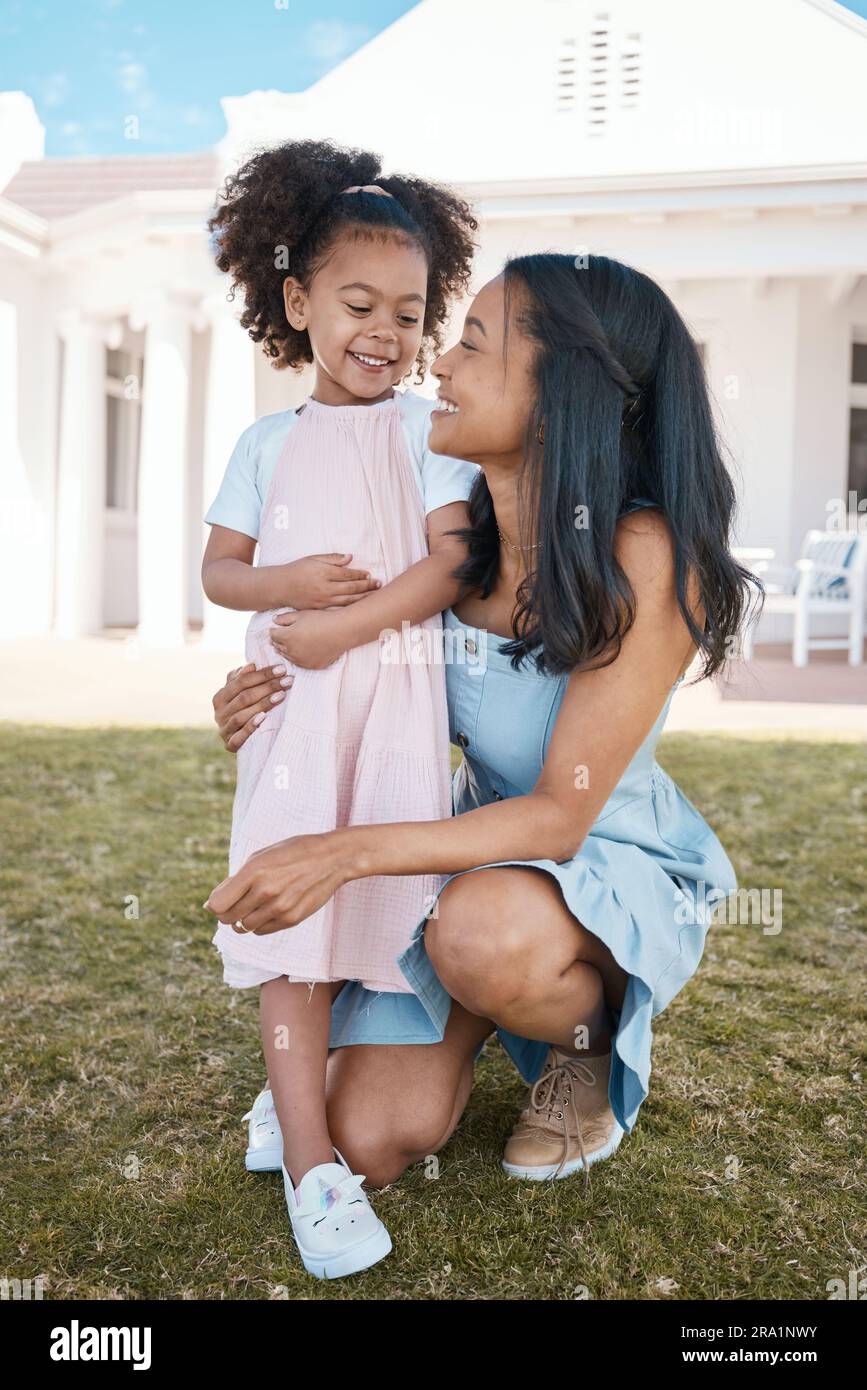 Mutter, lächle und umarme das Mädchen draußen im Garten, knüpfe eine Beziehung und habe Spaß ...