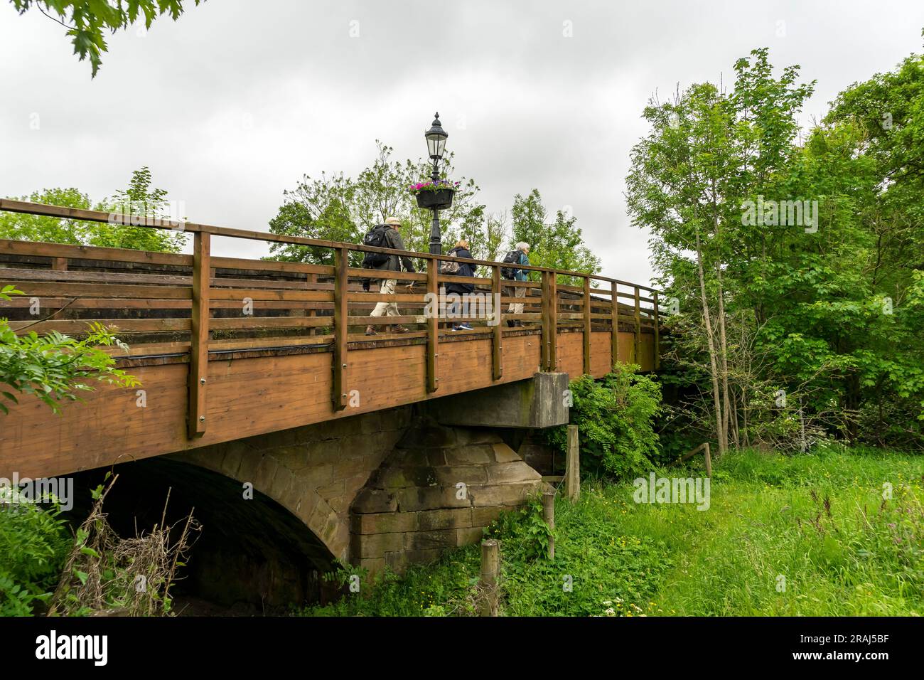 Fußgängerbrücke aus Holz entlang der alten Steinbrücke, die den Fluss ...
