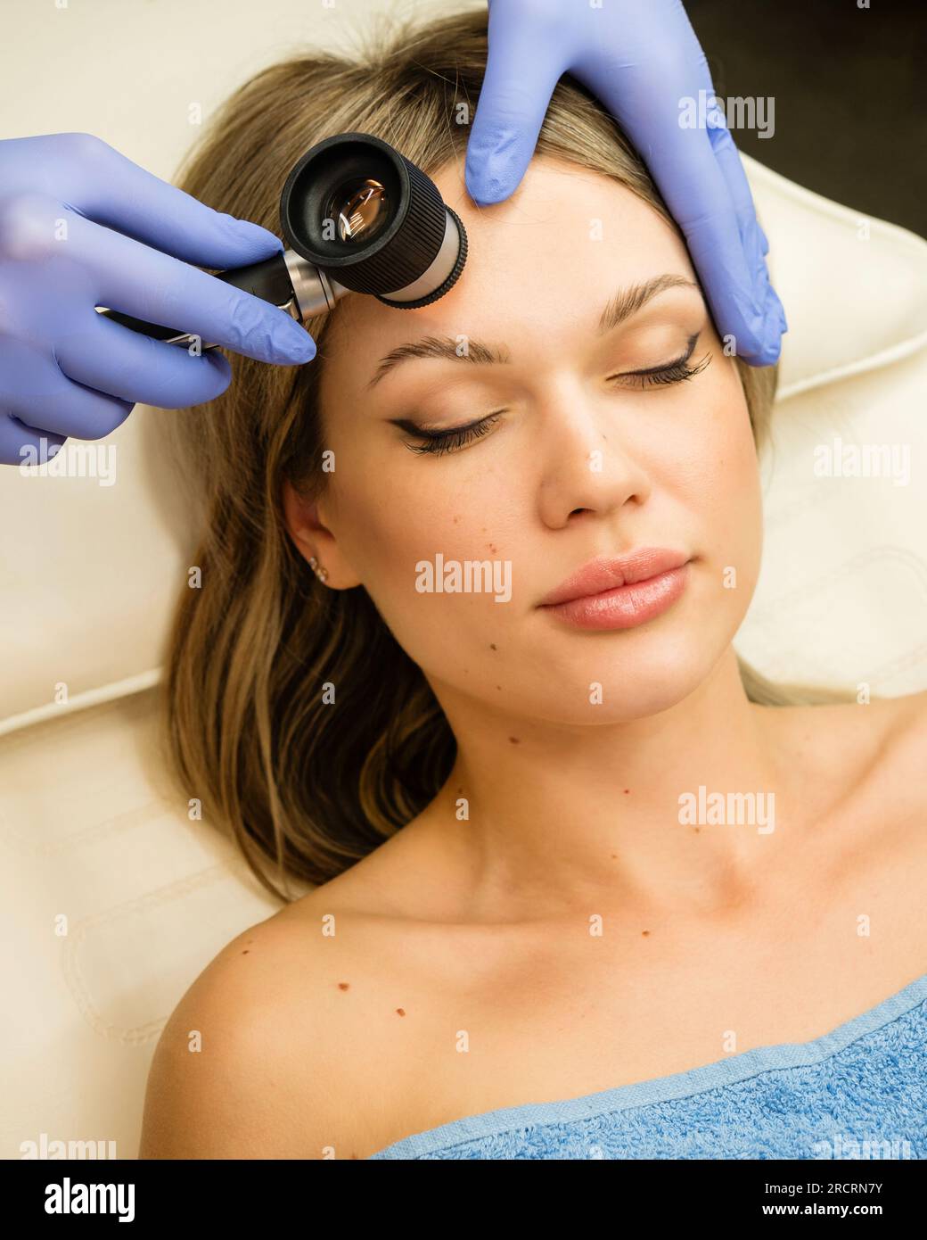 Der Dermatologe untersucht das Muttermal des Patienten mit dem ...