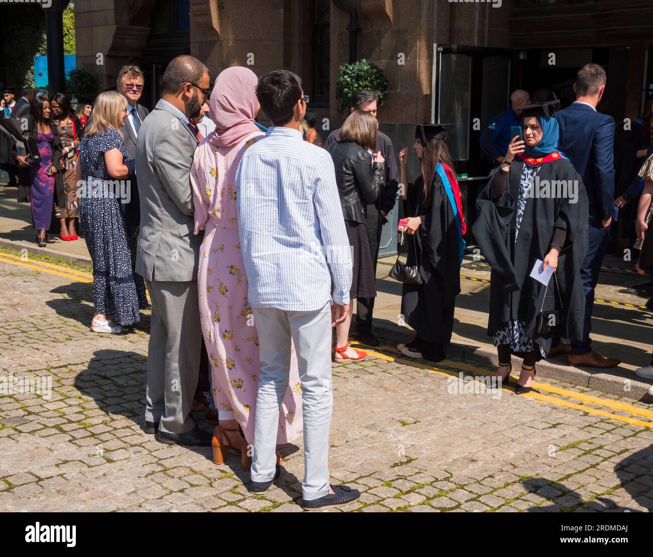 Das Bild zeigt Absolventen-Gruppen mit Familie und Freunden, die ihre ...