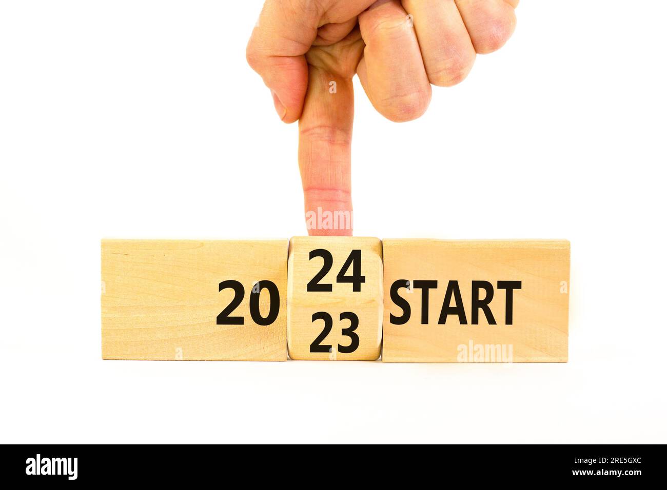 2024 Symbol für Neujahr starten. Ein Geschäftsmann dreht einen Holzwürfel um und ändert die ...