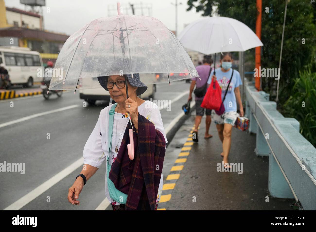Women uses umbrella during enhanced rains brought about by Typhoon ...