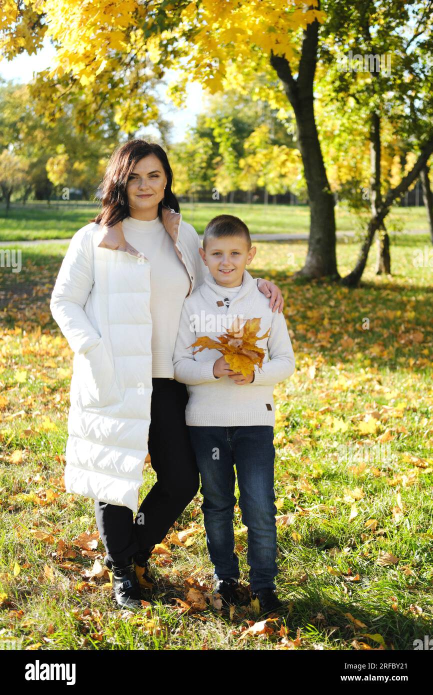 Mutter mit Sohn auf einem Spaziergang im Herbstpark. Die Familie schaut ...