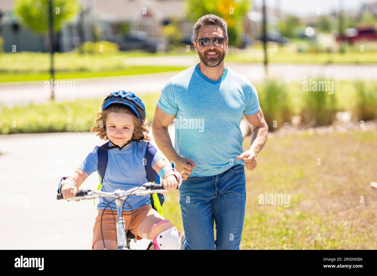 Vaterschaft von Vater und Sohn beim Radfahren im sonnenbeleuchteten ... Vaterschaft von Vater und Sohn beim Radfahren im sonnenbeleuchteten ...