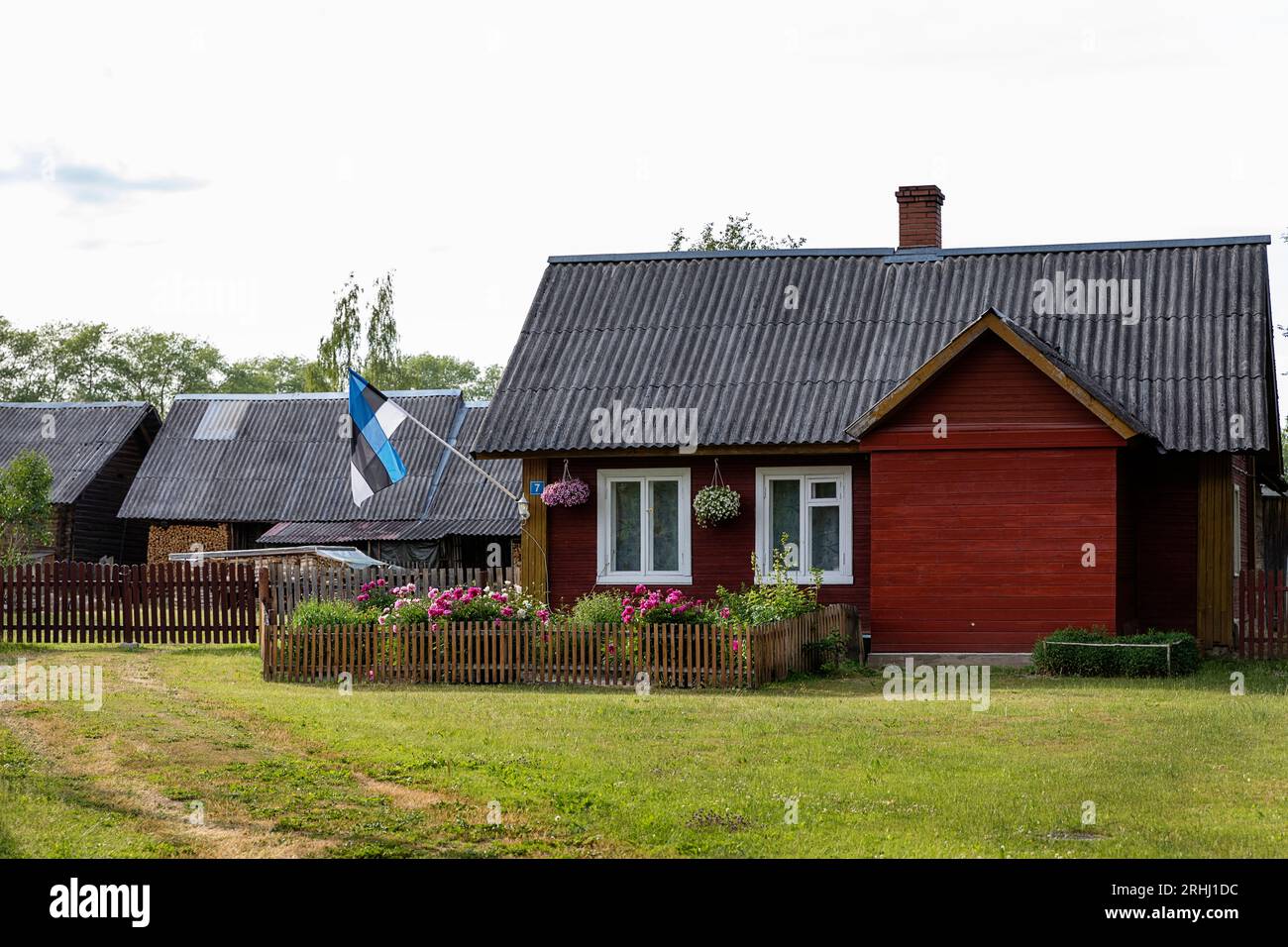 Traditionelle Seto-Holzhäuser mit Nationalflaggen im Dorf Obinitsa nahe ...