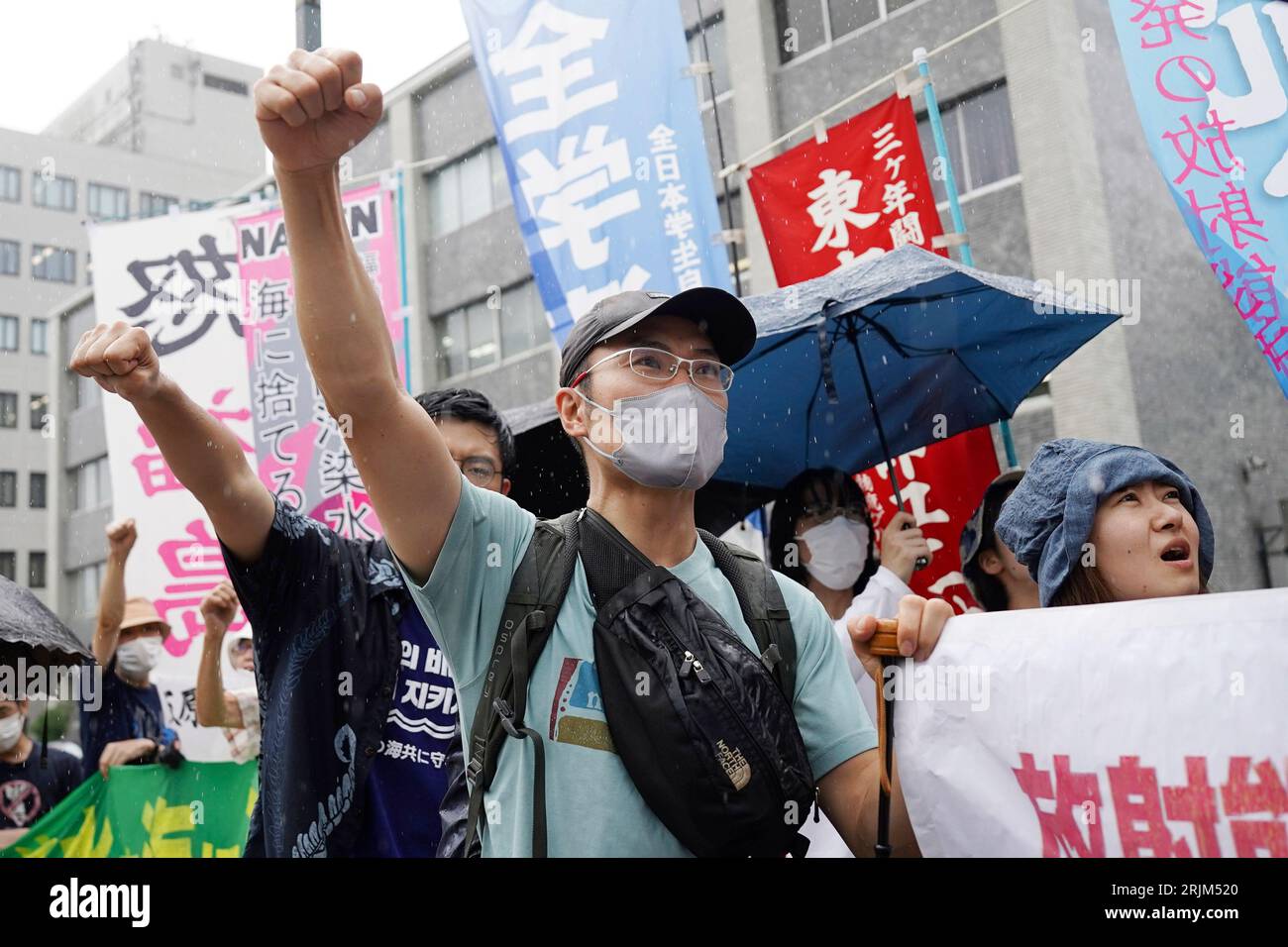 Protesters chant in the rain during a rally against the treated ...