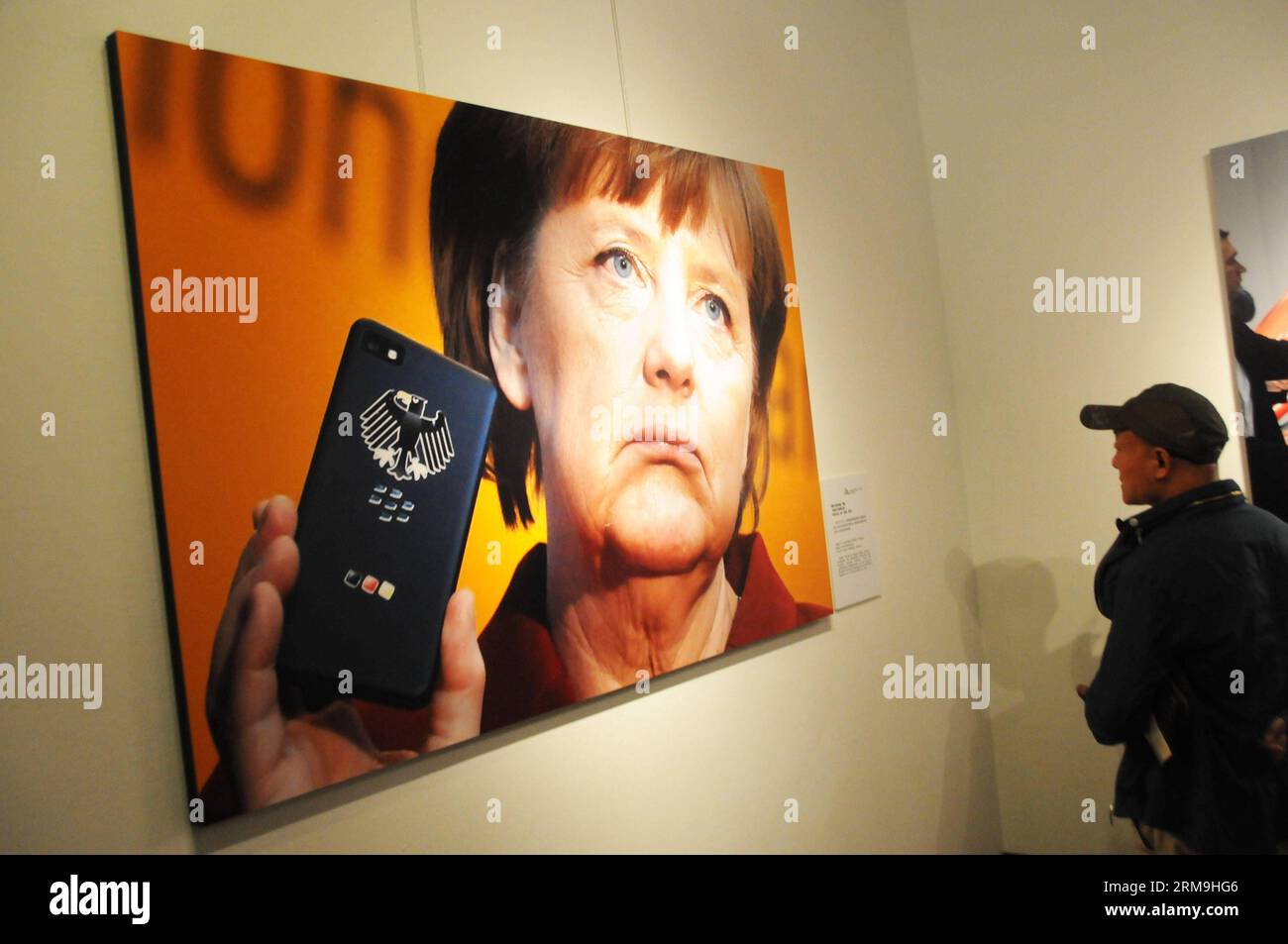 Ein Besucher sieht das Foto Angela Merkel und ihr Handy auf dem 10 ...