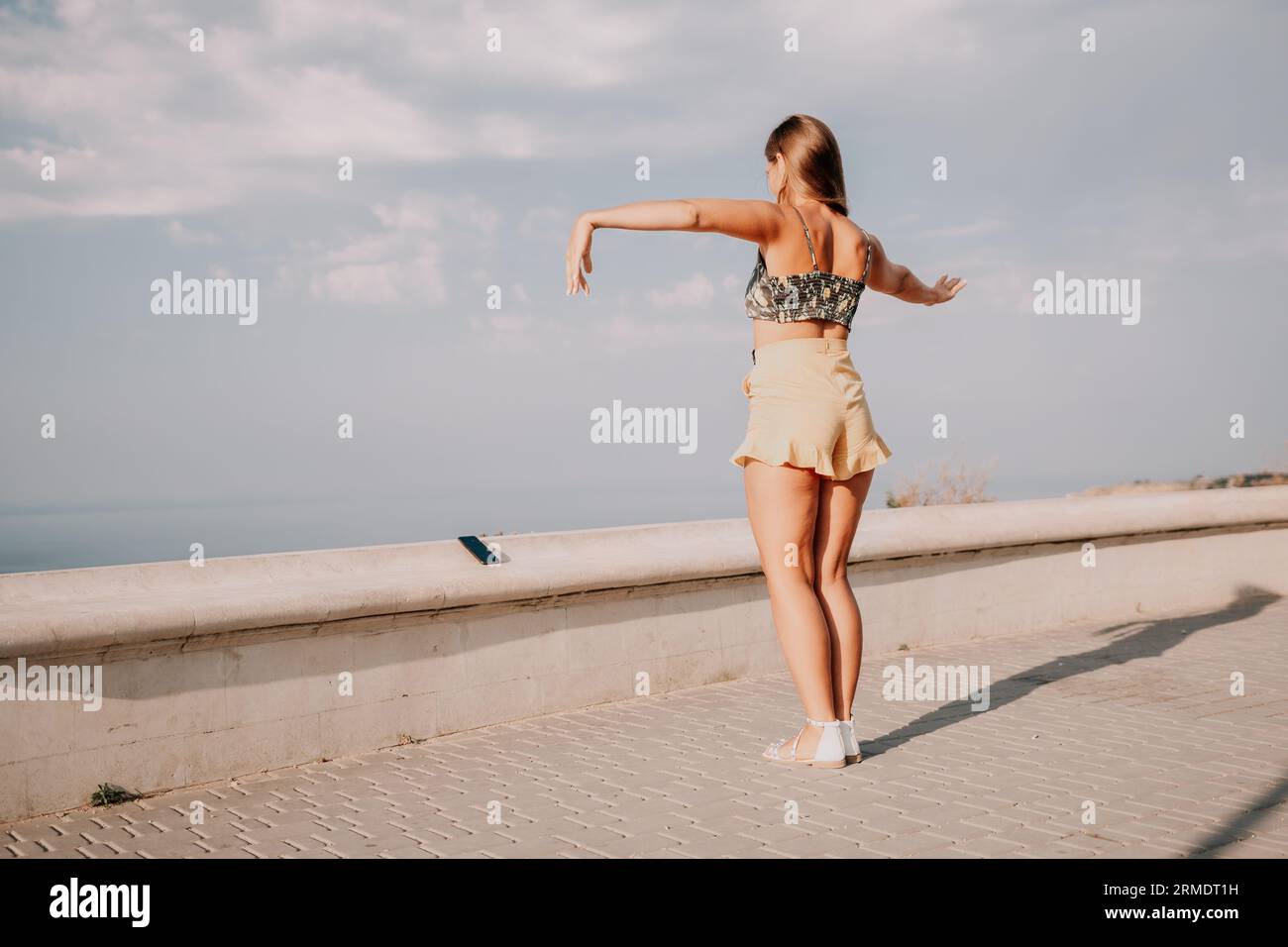 Frauen-Sommertanz. Silhouette einer glücklichen Frau, die tanzt, sich dreht und ihre Hände zum ...