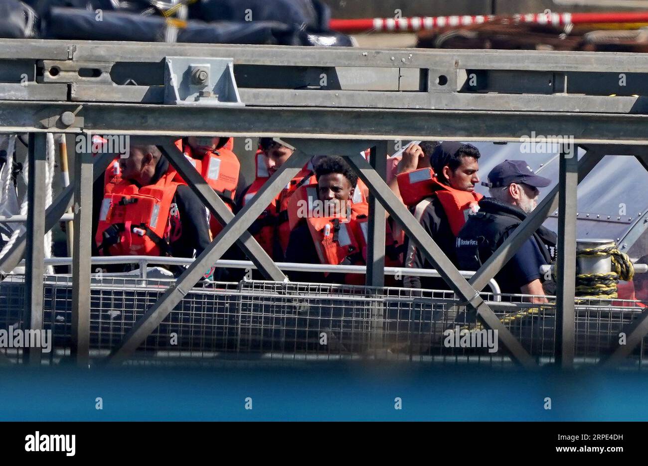 Eine Gruppe von Menschen, die als Migranten gelten, wird nach einem ...