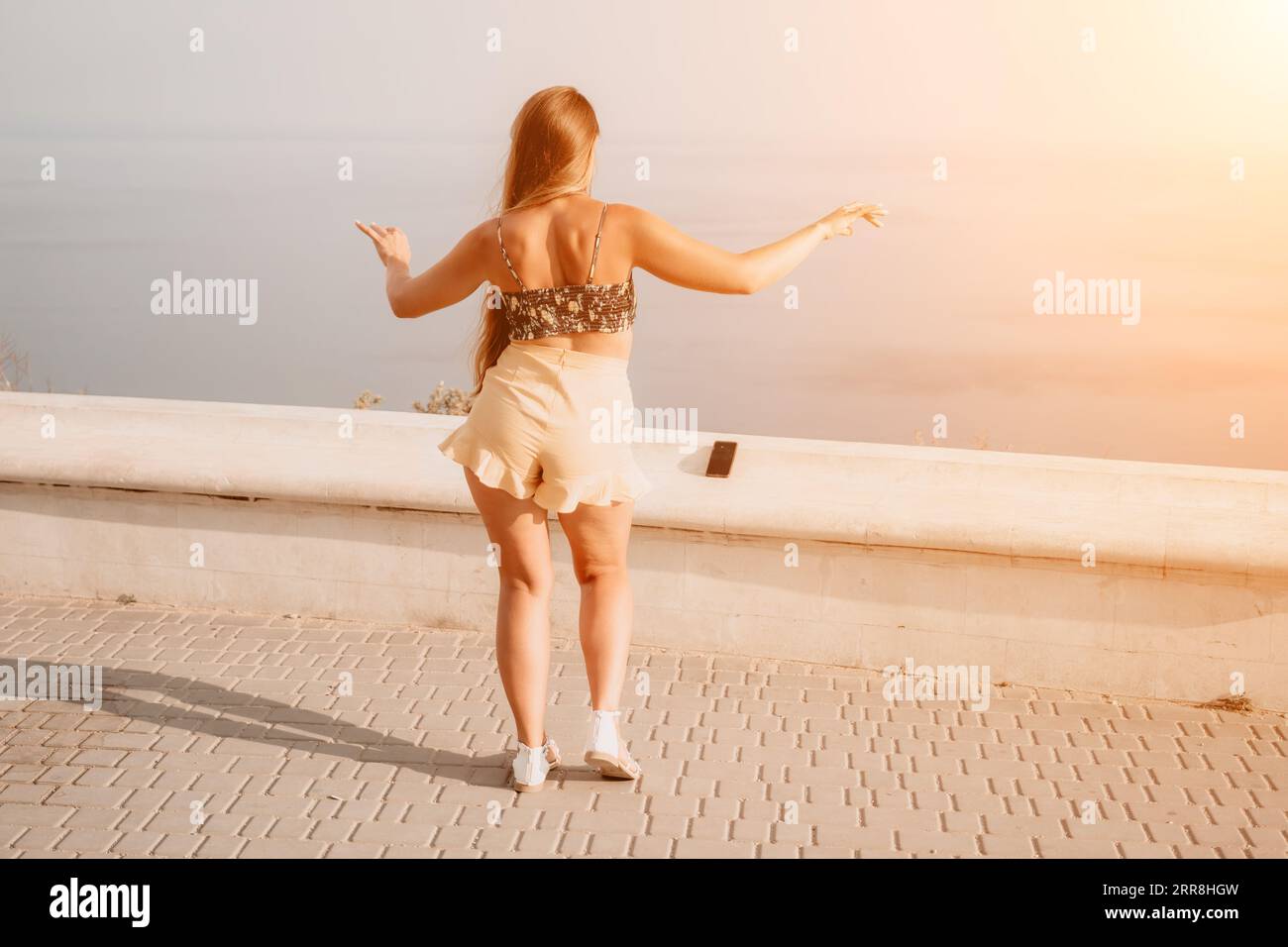 Frauen-Sommertanz. Silhouette einer glücklichen Frau, die tanzt, sich dreht und ihre Hände zum ...