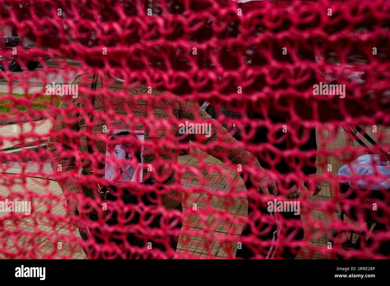 Ada Salvador hangs around her neck a portrait of her brother Isidro ...