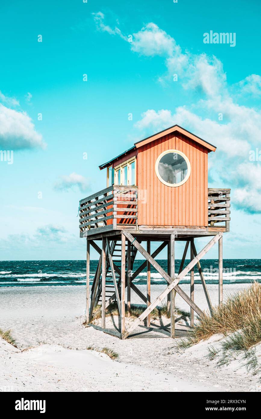 Roter hölzerner Rettungsschwimmer-Aussichtsturm auf Stelzen an der ...