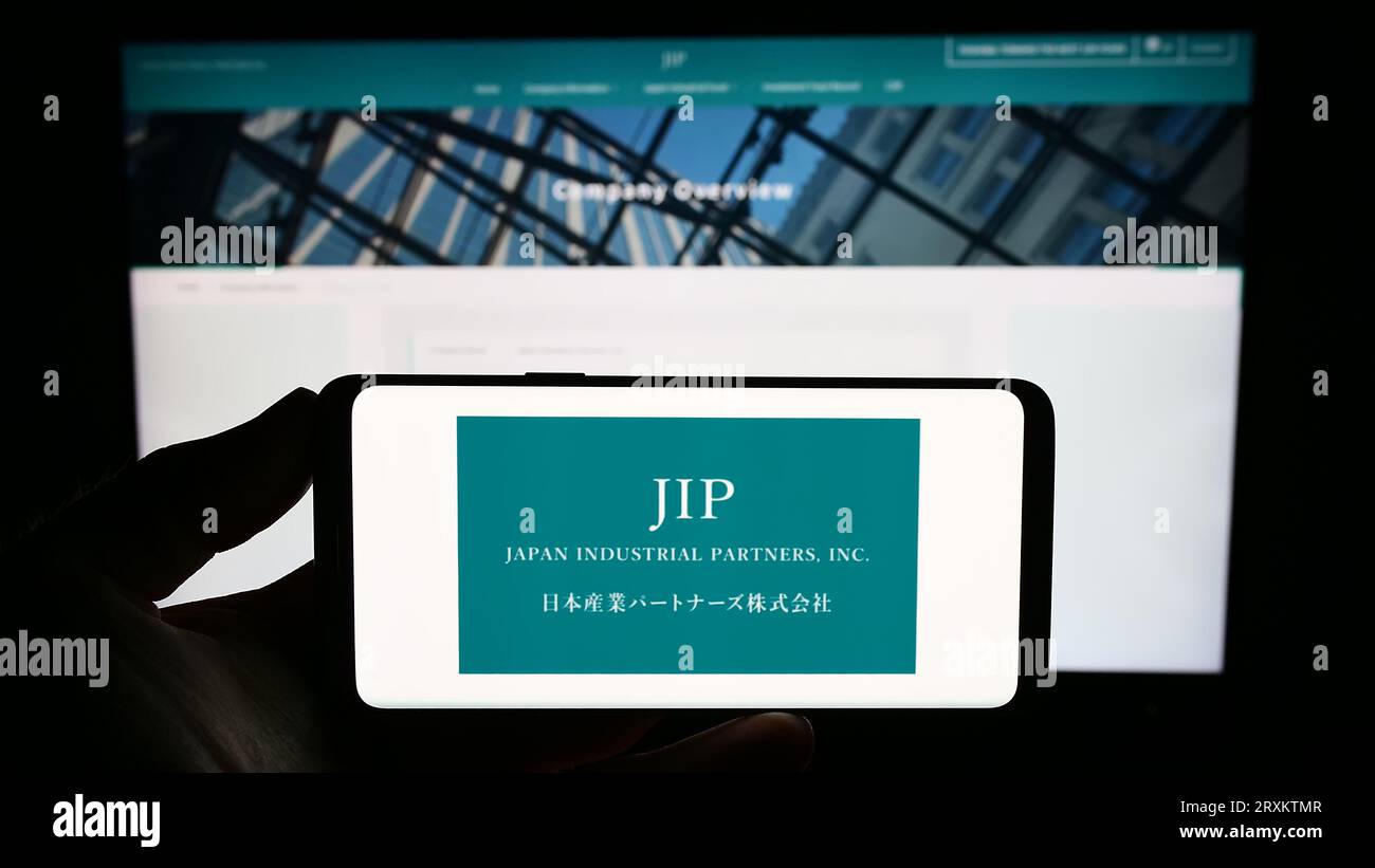 Person, die ein Smartphone mit dem Logo der Firma Japan Industrial ...