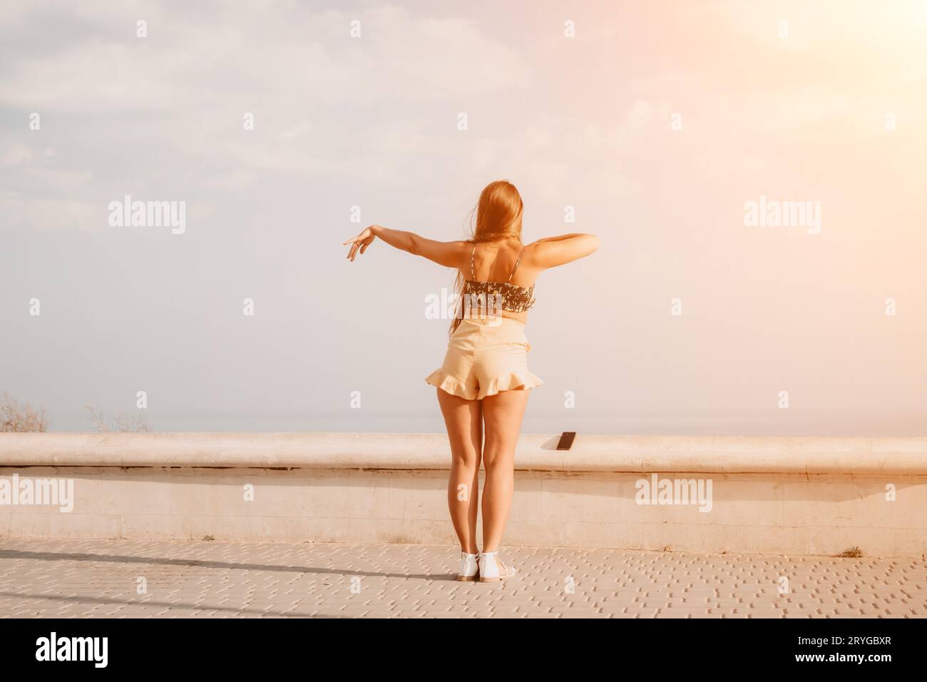 Frauen-Sommertanz. Silhouette einer glücklichen Frau, die tanzt, sich dreht und ihre Hände zum ...