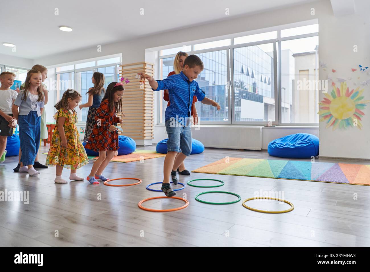 Kleine Kindergartenkinder mit Lehrerinnen auf dem Boden im ...