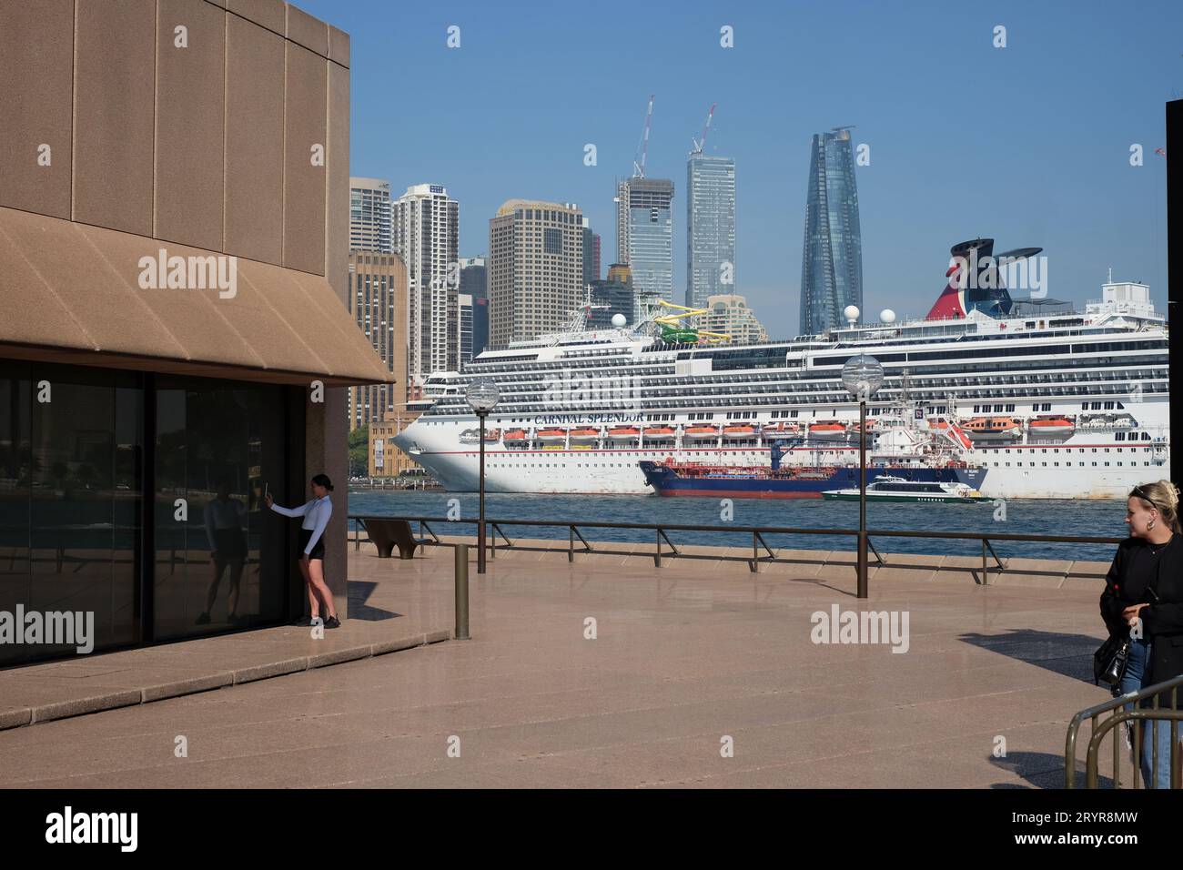 Eine Frau macht ein Selfie auf dem Sydney Opera House Northern Broadwalk, ein Kreuzfahrtschiff ...