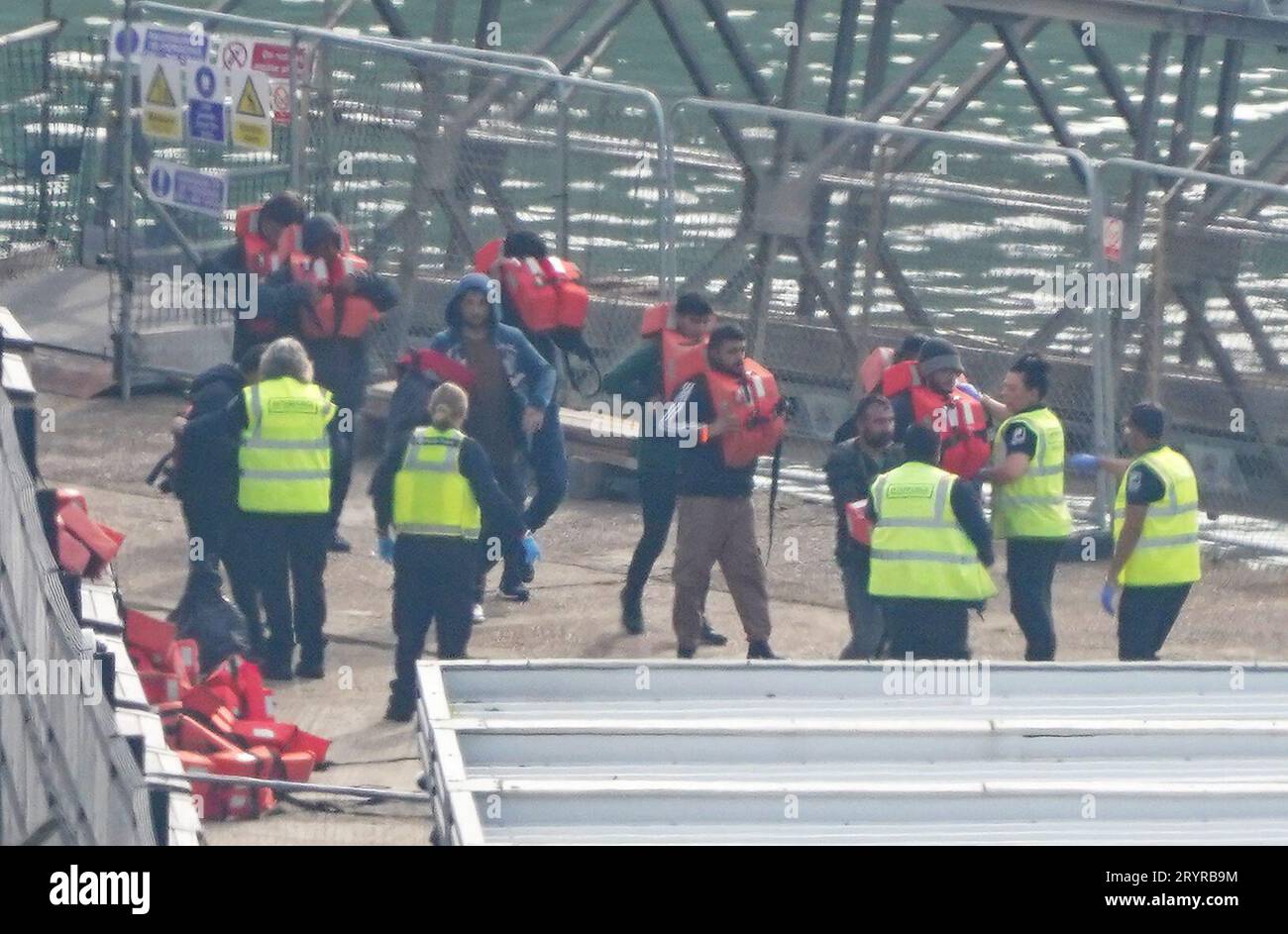 Eine Gruppe von Menschen, die als Migranten gelten, wird nach einem ...